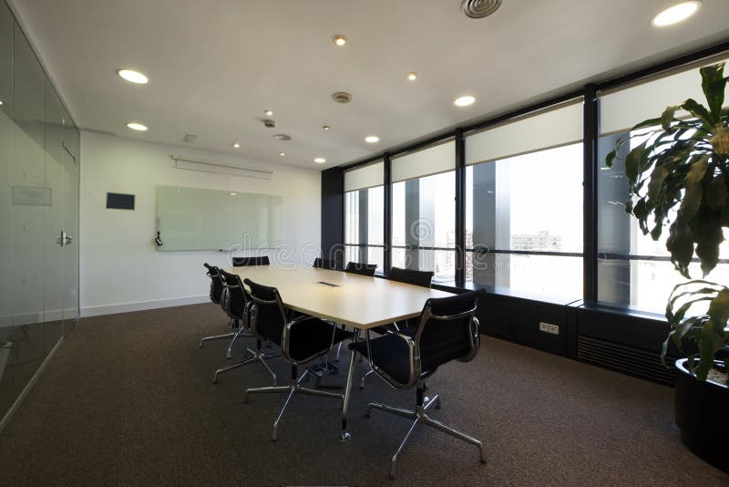 Boardroom with Long Wooden Table with Black Swivel Chairs and Wall with ...