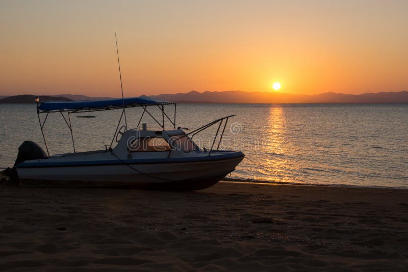 Boat on beach at sunset stock image. Image of coastline - 69999077