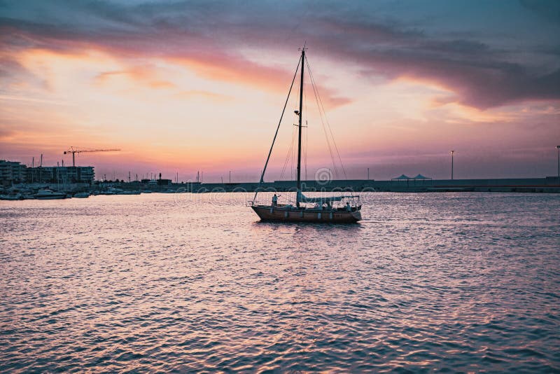 Boat on calm sea at sunset stock photo. Image of vacation - 243260550