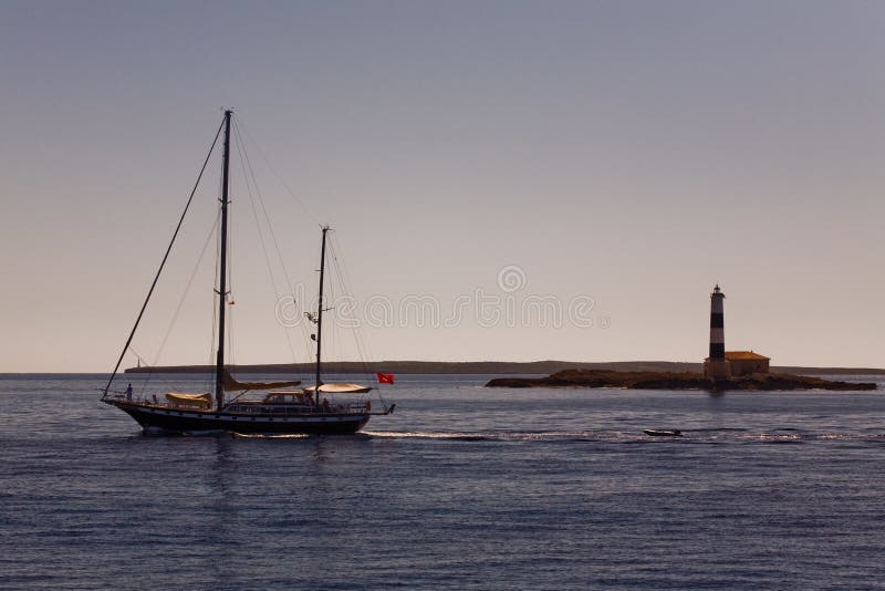 Boat and Lighthouse at Sunset Stock Photo - Image of floating ...