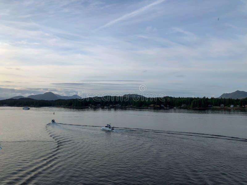 Boat Making a Ripple in the Water with Trees and Mountains in ...
