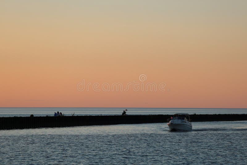 Boat Returning from Open Water at Sunset. Stunning Orange Sky in the ...