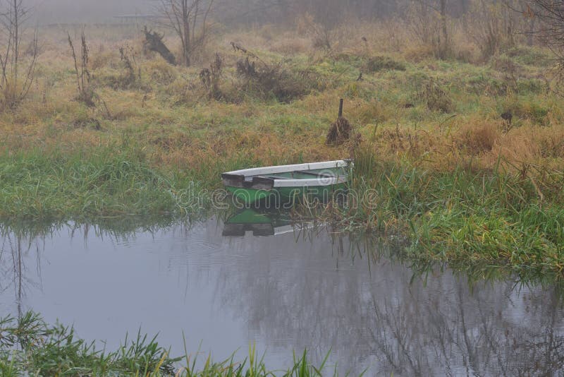 A Boat by the River Bank in the Fog Under a Willow Tree on an Autumn ...
