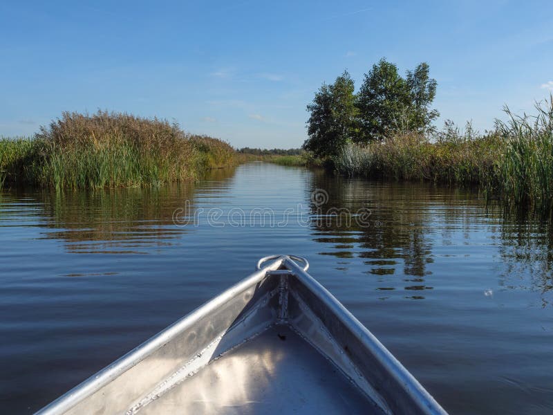 Boat Sailing Down a River, Surrounded by Lush Greenery on Either Side ...