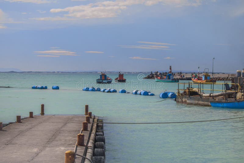 Boats in a Harbor with Turquoise Water and Peer in the Background ...