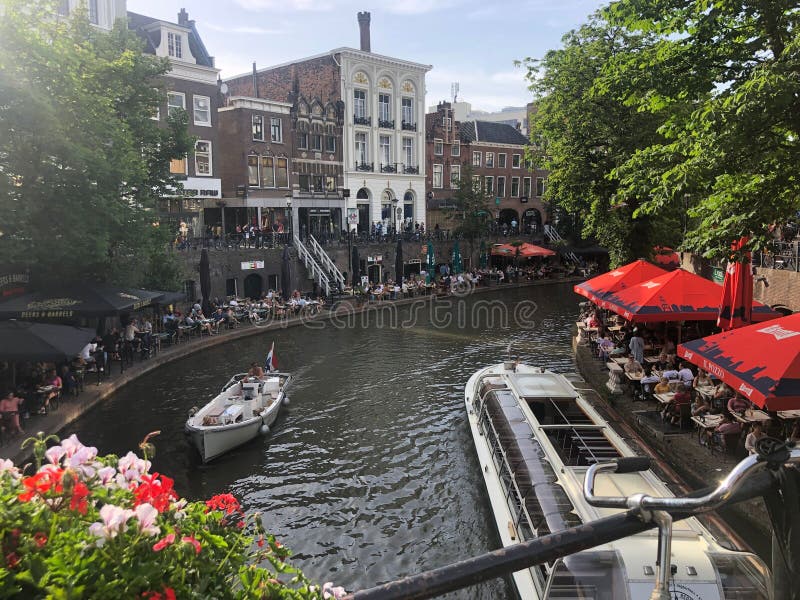 Boats Sailing on a River and Outdoors Cafes Along the Riverside ...
