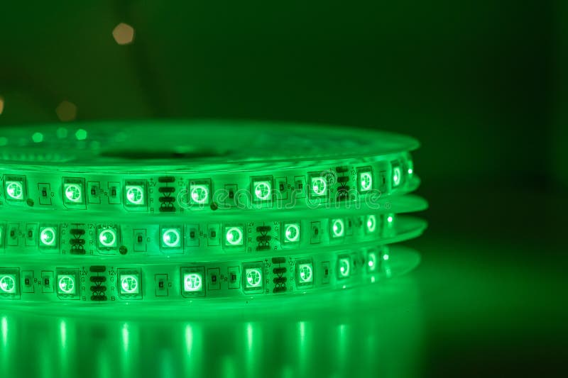 Bobbin with Roll of Glowing LED Strip Lighting Placed on Table, Green ...
