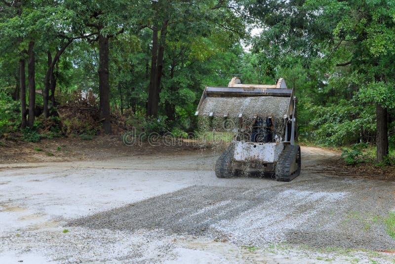 A Bobcat Mini Loader is Moving Bucket of Crushed Stone Gravel during ...