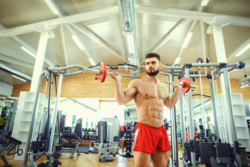 Bodybuilder with a Bar Barbell Makes Exercises in the Gym Stock Photo ...