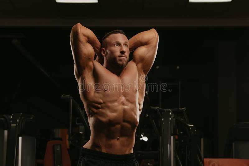 A Bodybuilder with a Beard is Doing a Stomach Vacuum Pose during a ...