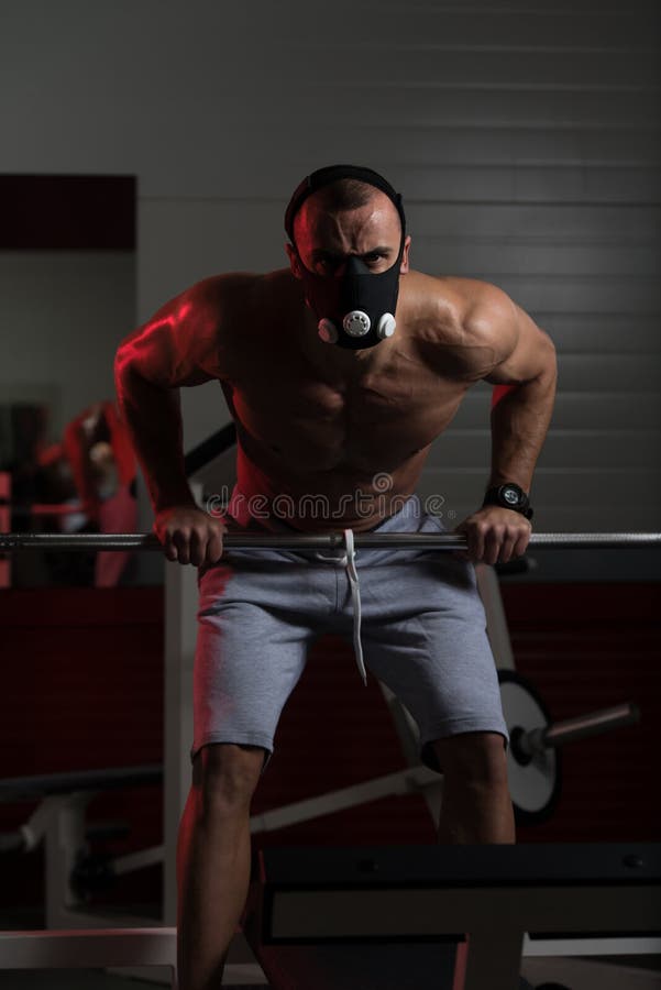 Bodybuilder Exercising Push-Ups on Barbell in Elevation Mask Stock ...