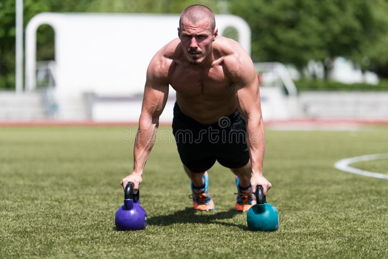Bodybuilder Doing Push Ups on Grass with Kettle-bell Stock Photo ...
