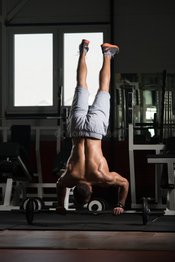 Bodybuilder Exercising Push-Ups on Barbell in Elevation Mask Stock ...