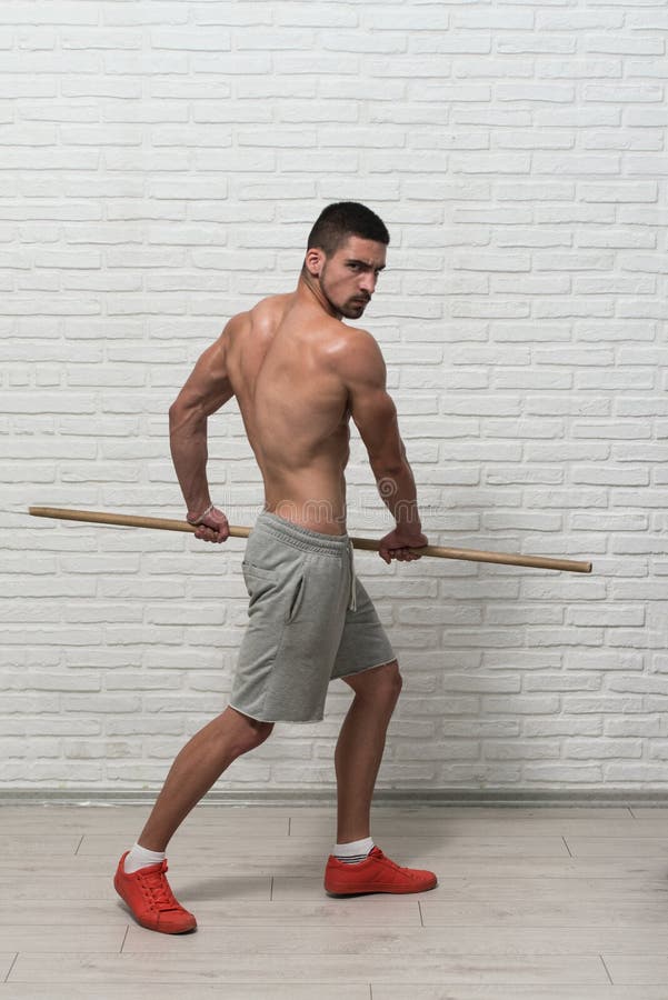 Bodybuilder is Exercising with Stick at the Wall Stock Photo - Image of ...
