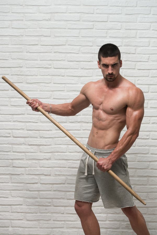 Bodybuilder is Exercising with Stick at the Wall Stock Image - Image of ...