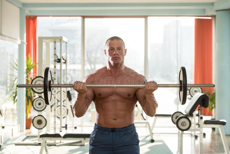Bodybuilder Performing Biceps Curls with a Barbell Stock Image - Image ...