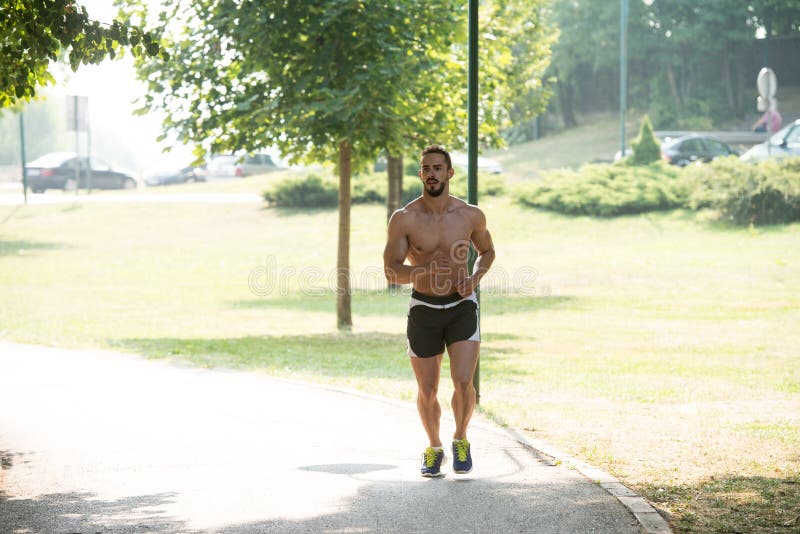 Bodybuilder Runner Running through the Spring Park Road Stock Image ...