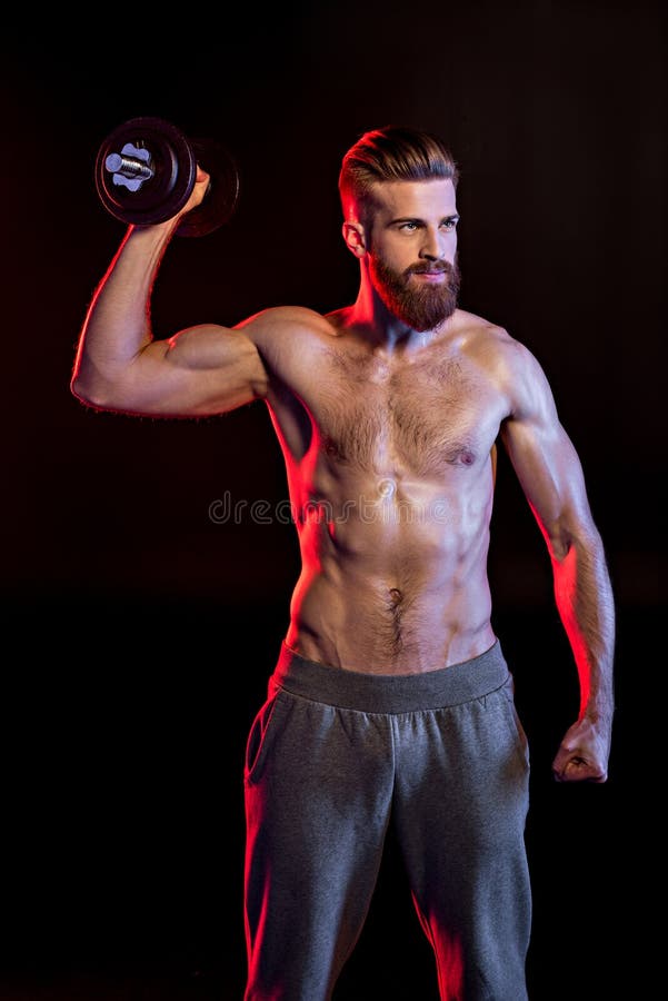 Bodybuilder Training with Dumbbell Isolated on Black with Dramatic ...