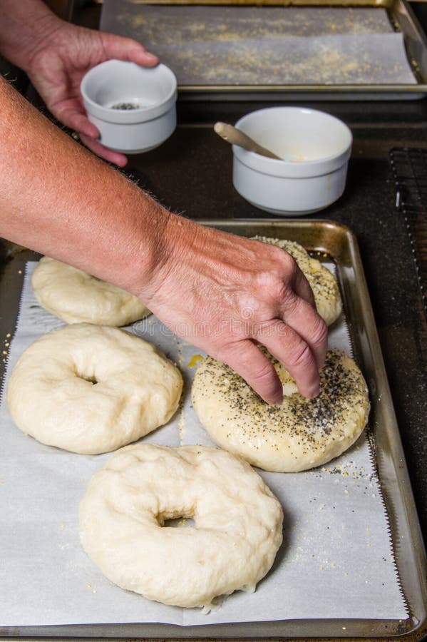 Boiled Bagels Being Seasoned for Baking Stock Photo - Image of ...