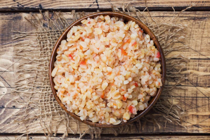 Boiled Bulgur with Tomatoes in a Wooden Bowl Stock Photo - Image of ...