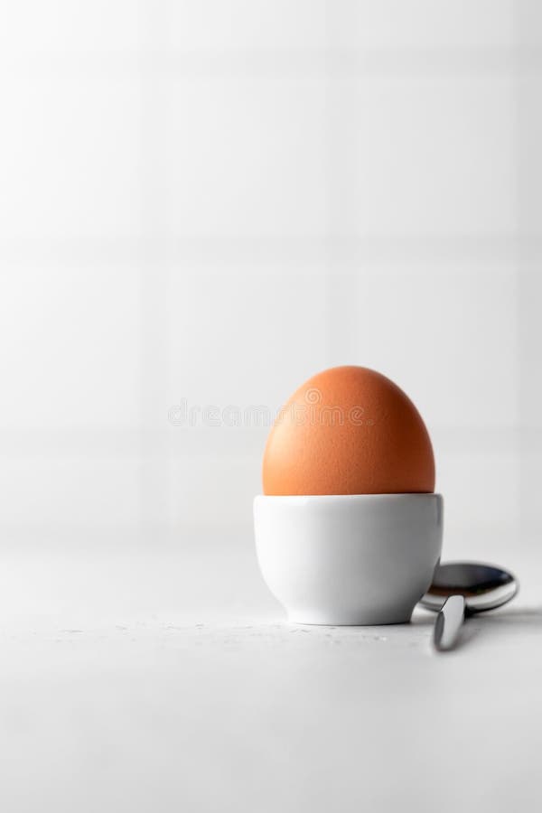 Boiled Egg in an Egg Stand and Spoon on a White Kitchen Background with ...
