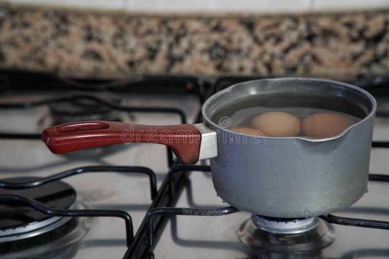 Boiled Eggs in Dipper of Water on the Kitchen Stove Stock Photo - Image ...