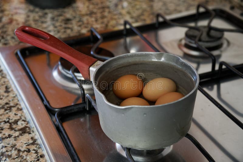 Boiled Eggs in Dipper of Water on the Kitchen Stove Stock Image - Image ...