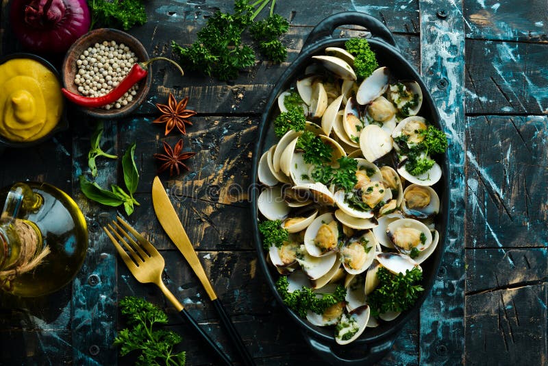 Boiled Shellfish in Shells with Garlic and Parsley in a Black Plate ...