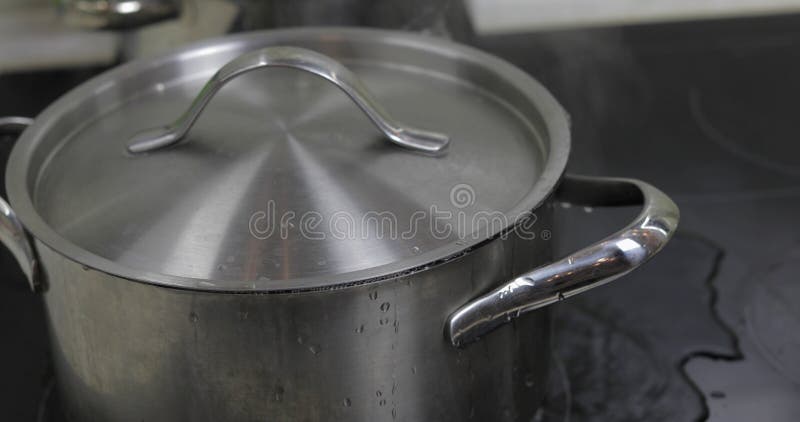 Boiling Water in the Pan that is Covered with a Lid in the Kitchen ...