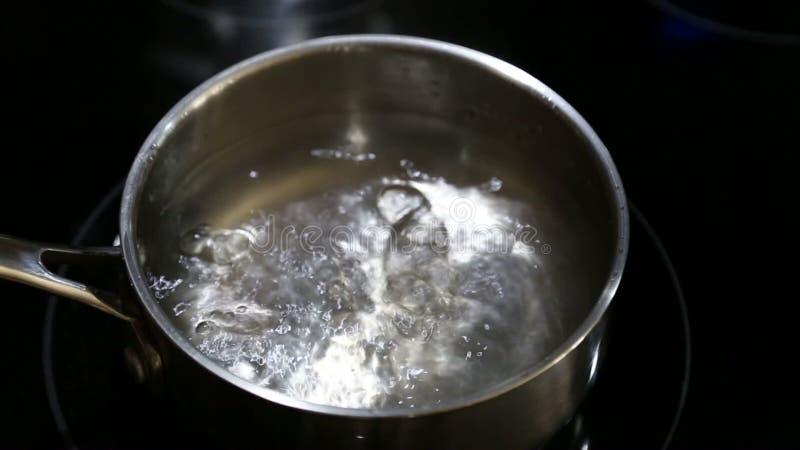Pot of Boiling Water on Gas Stove with Hand Sprinkling Salt into it ...