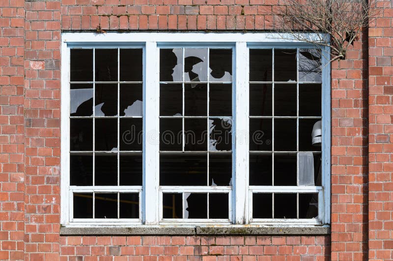 Broken Panes of Glass in Three Section Window Surrounded by Red Bricks ...
