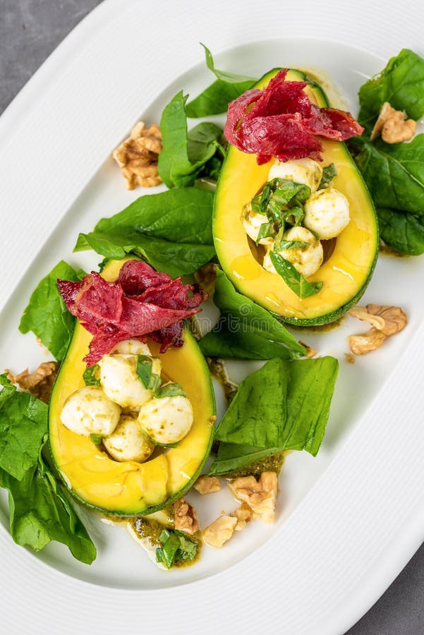 Bolas De Queijo Boconcini Em Metades De Abacate Servidas Com Salada Em ...