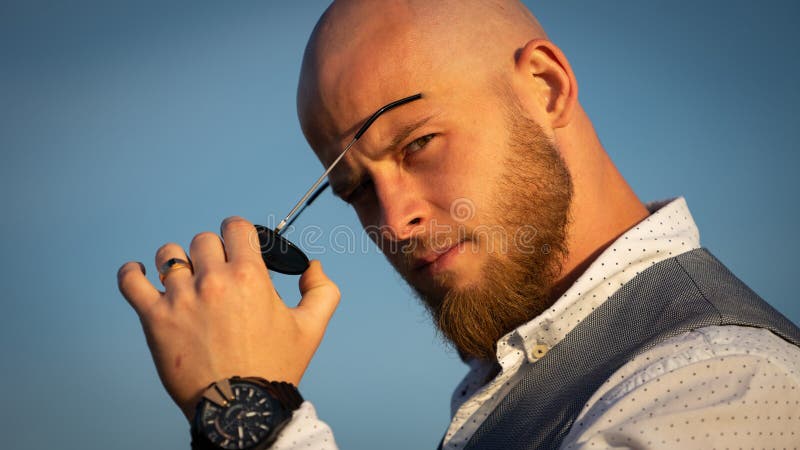 Bold Guy with a Stylish Beard and Sunglasses on a Sky Background during ...