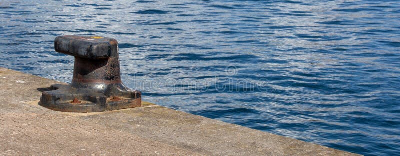 Bollar on Pier with Blue Water in Background Stock Photo - Image of ...