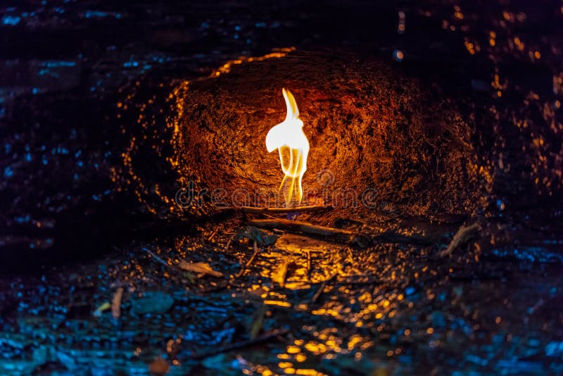 Bonfire in a Cave Surrounded by Rocks and Branches during the Rain ...