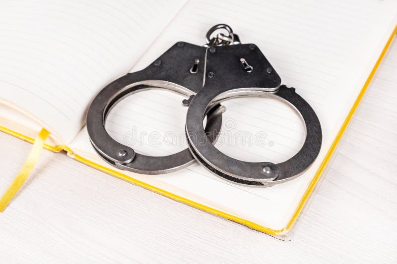 Book and Handcuffs stock photo. Image of note, notepad - 382200246