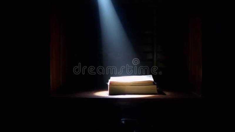 A Book Illuminated by a Single Spotlight in a Dark Room, Creating a ...