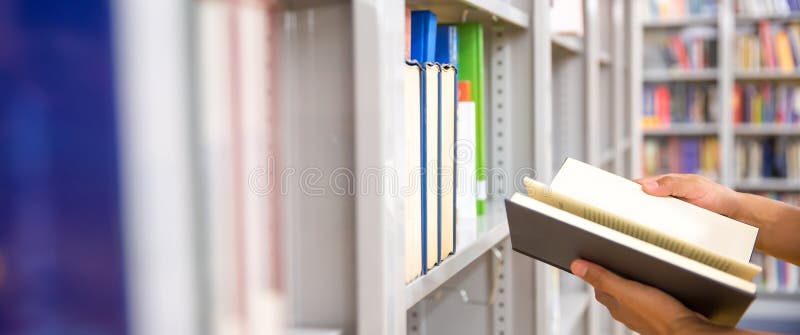Close Up Hand Choosing and Open To Read a Book from Bookshelf in ...