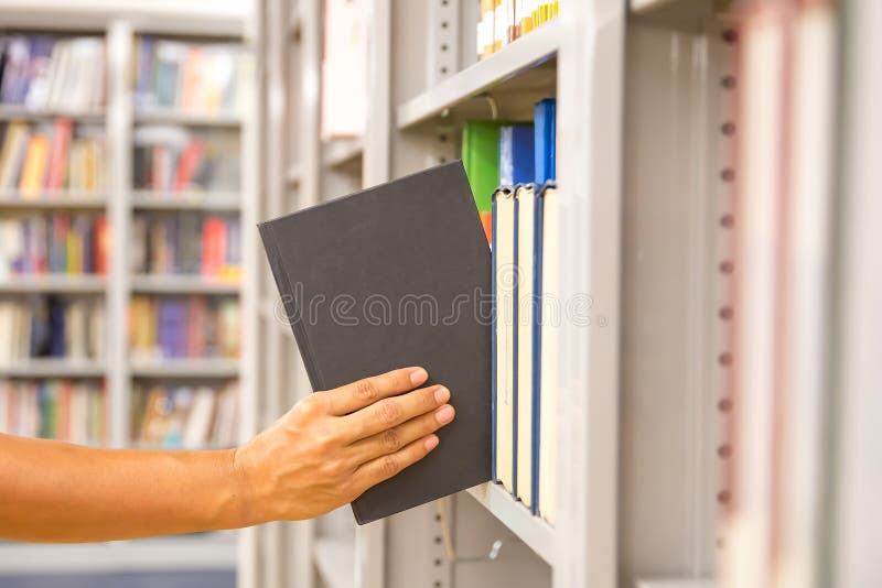 Close Up Hand Choosing and Picking Books from Bookshelf in Library ...