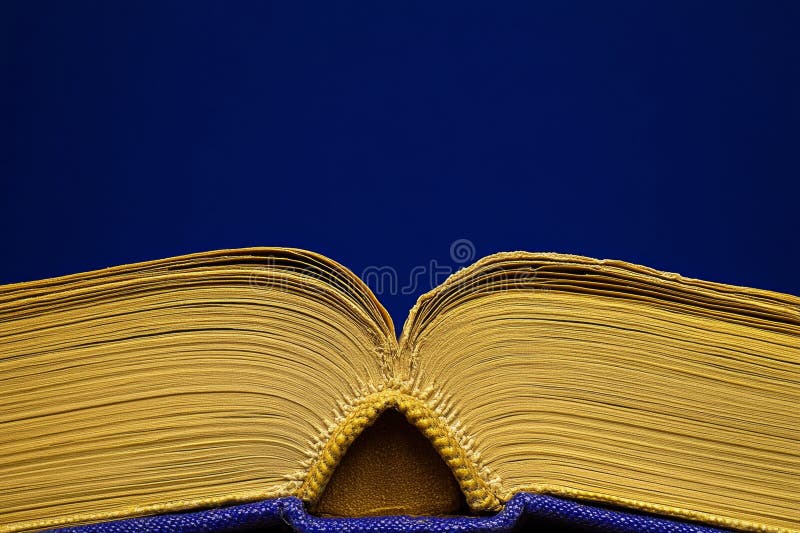 A Book Lies Open, Its Pages Spread Wide Against a Blue Backdrop ...