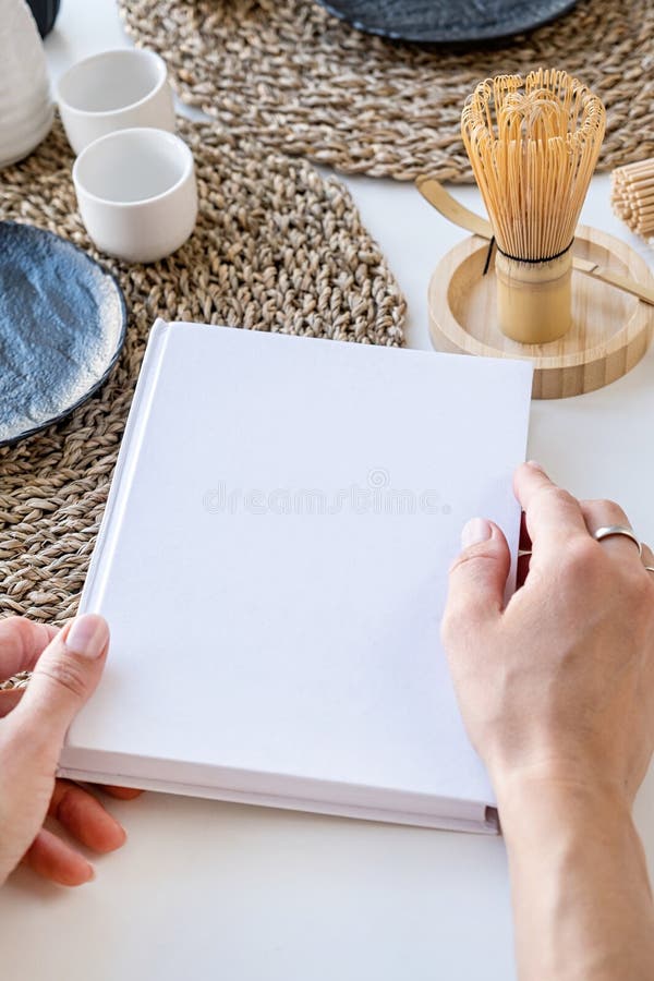 Book Mockup Design. Hands Holding Blank White Book on Dining Table ...