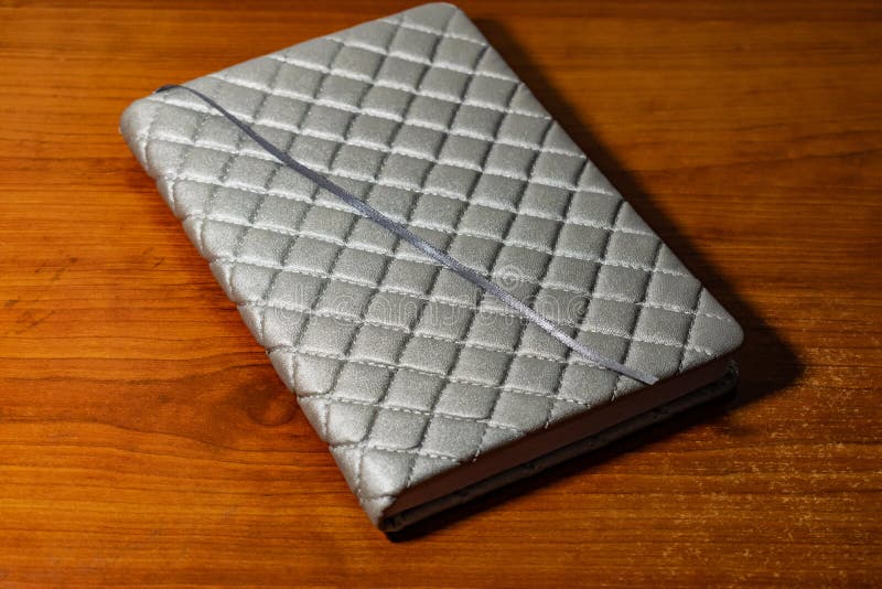 A Book, a Notebook with a Checkered Pattern on a Wooden Table in ...