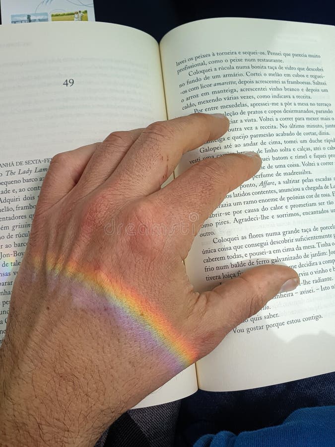 Book Reading. Left Hand on Top of the Pages with Rainbow Light Falling ...