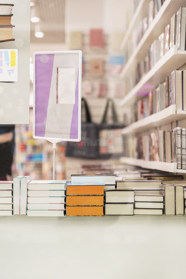 Book Stack on Table in Glass Showcase, Blurred Bookshelfes in Bookstore ...