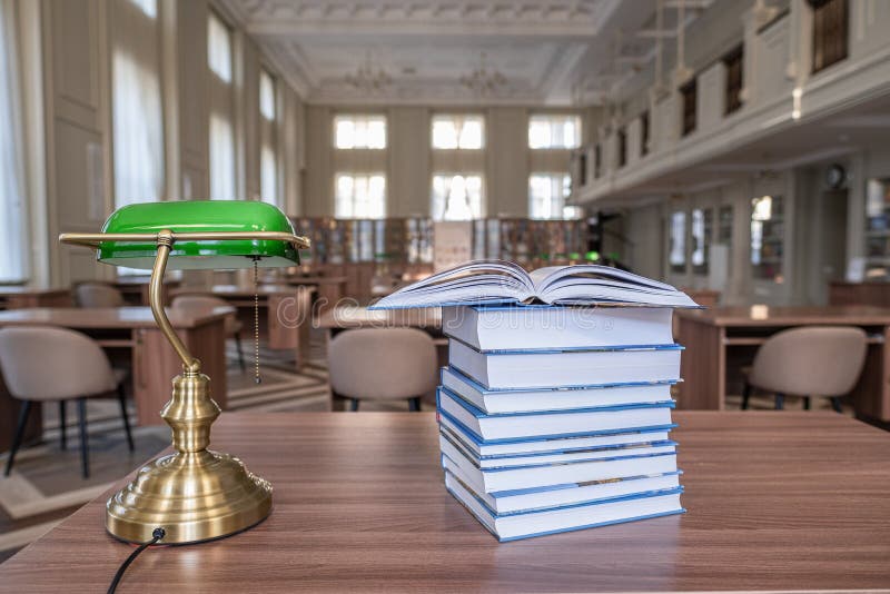 Book Stack on Wood Desk and Blurred Bookshelf in the Library Room ...