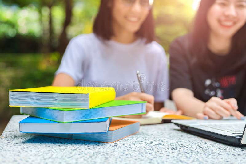 A Book on the Table and Happy Student Lerning on Laptop Stock Photo ...