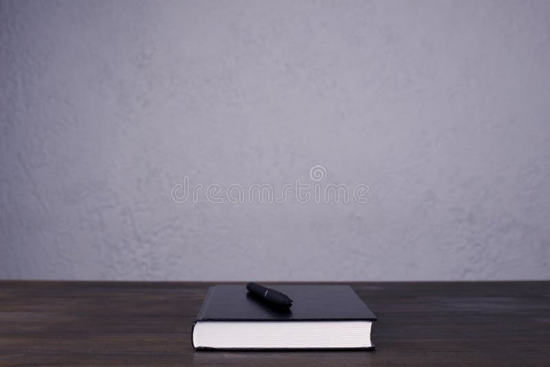 The Book is on the Table. Pen and Notepad. on a Wooden Background ...