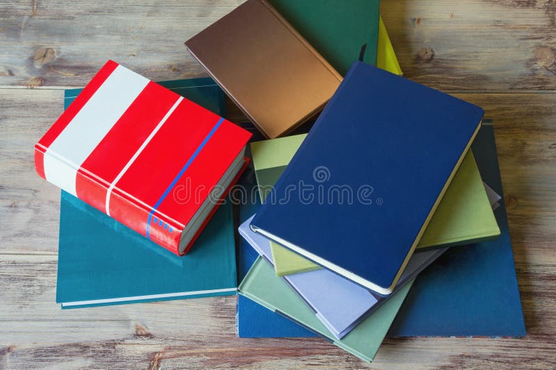 Six Books of Different Colors Resting on a Dark Wooden Shelf Stock ...