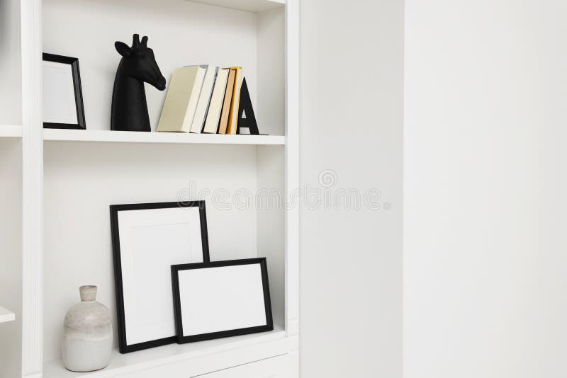Books, Frames and Different Decorative Elements on Shelving Unit ...