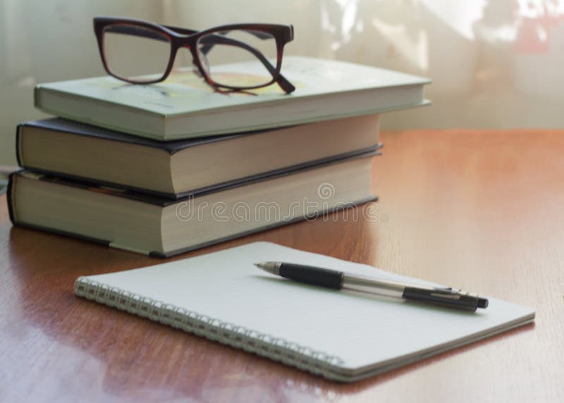 Stack of Books, Notebook with Pen and Glasses on the Table Stock Photo ...